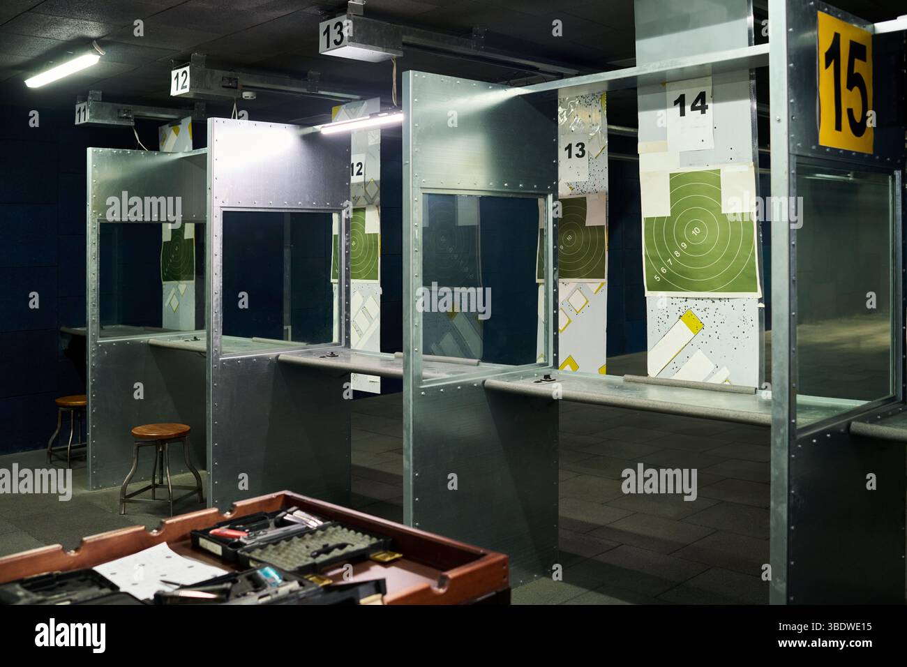 Indoor shooting range featuring multiple numbered shooting stalls with ...