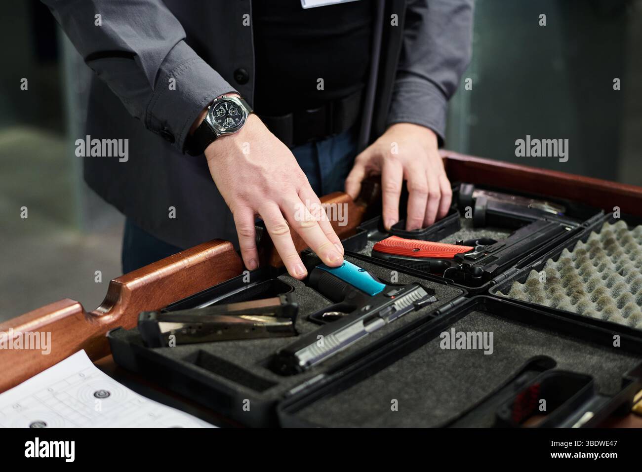 Technician carefully inspecting and handling various gun parts on ...
