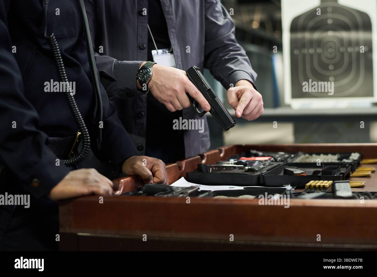 People at shooting range inspecting handgun and arranging equipment on ...