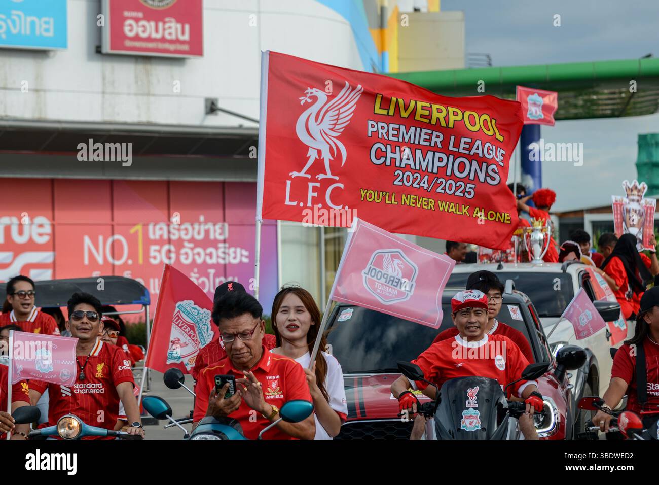 Liverpool FC fans proudly display banners and flags as they ride in a ...