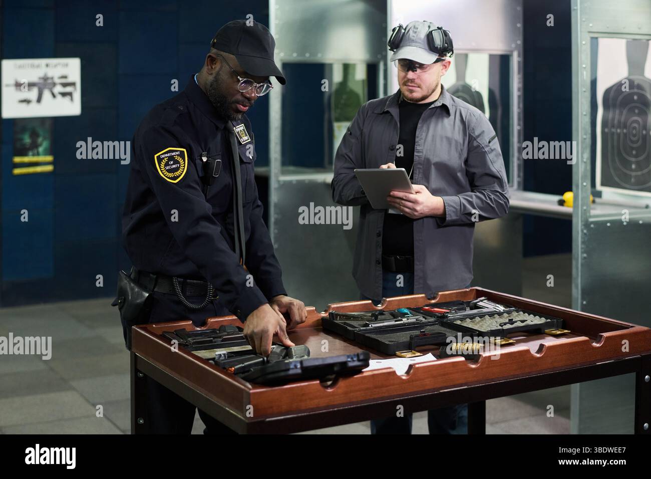 Police officer assisting colleague during firearm examination in a ...
