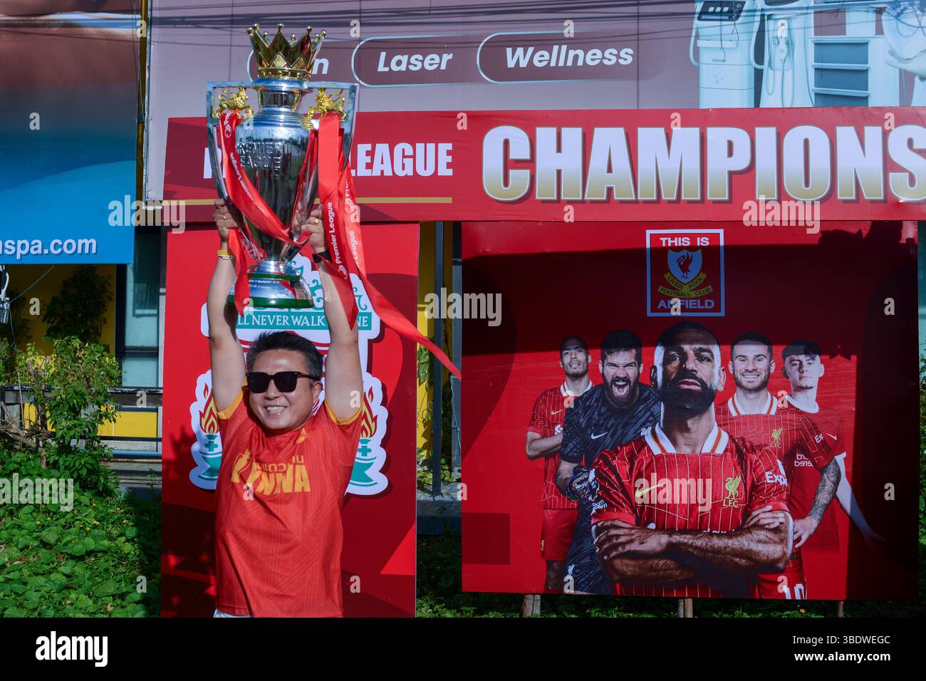 A passionate Liverpool FC fan poses proudly with a mock Premier League ...
