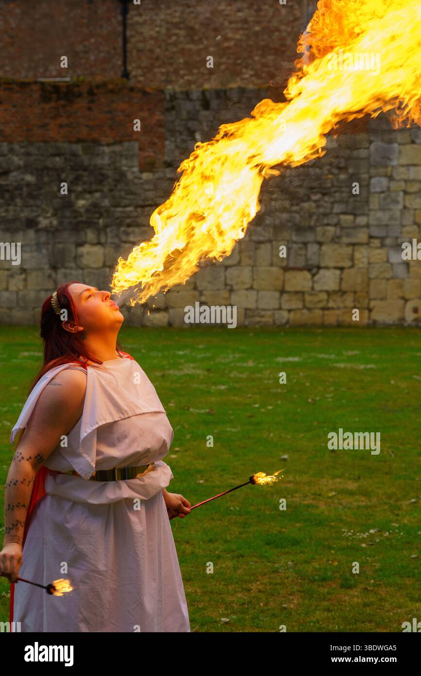 A fire breather performs in medieval costume with blazing torches and ...