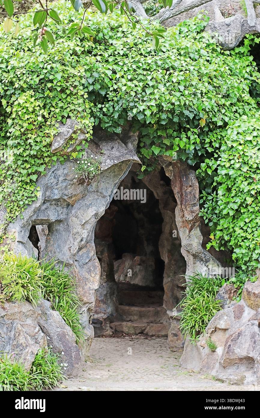 Stone grotto covered in green ivy Stock Photo - Alamy