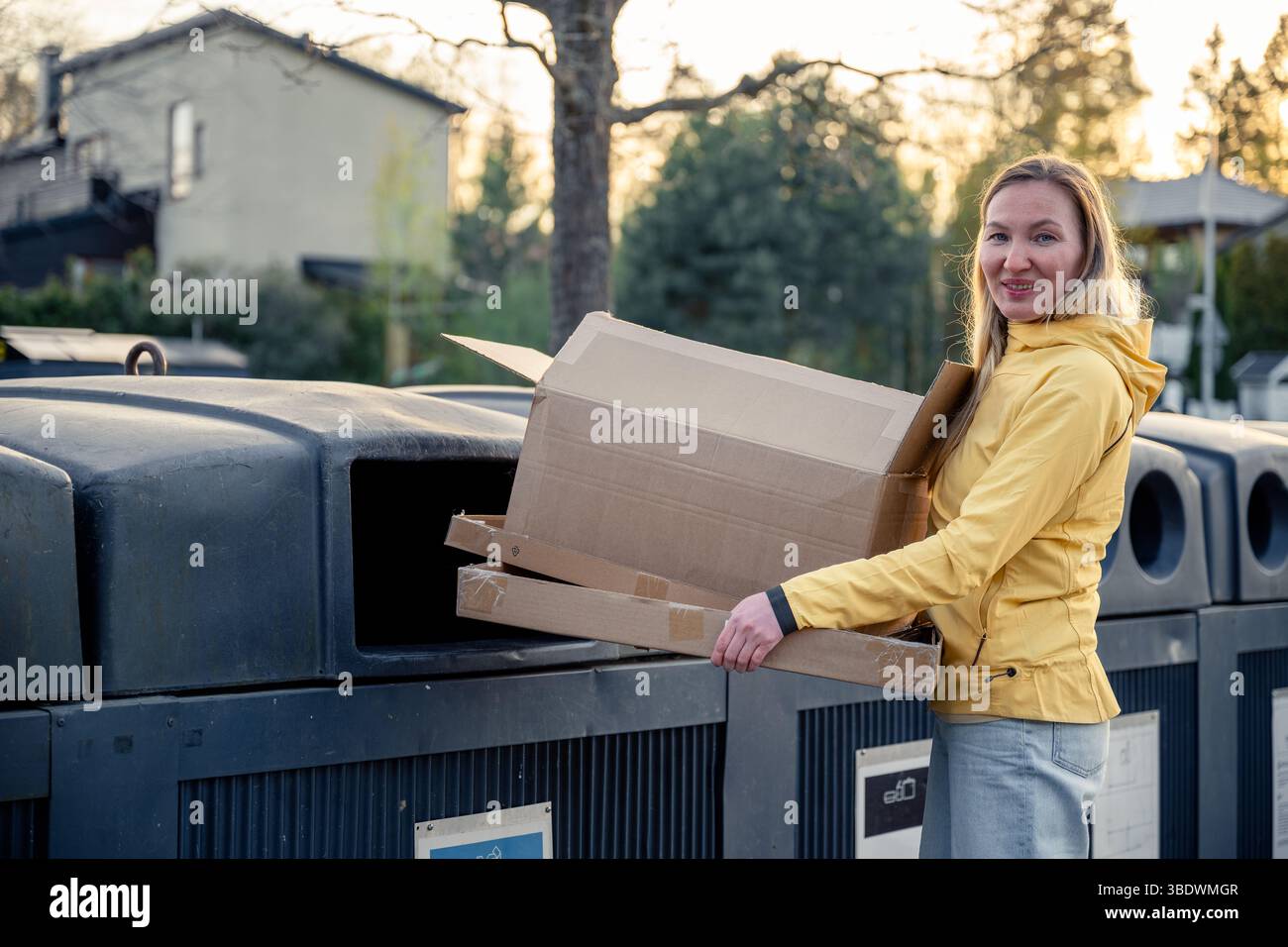woman puts cardboard trash in outdoor recycling bins Stock Photo - Alamy