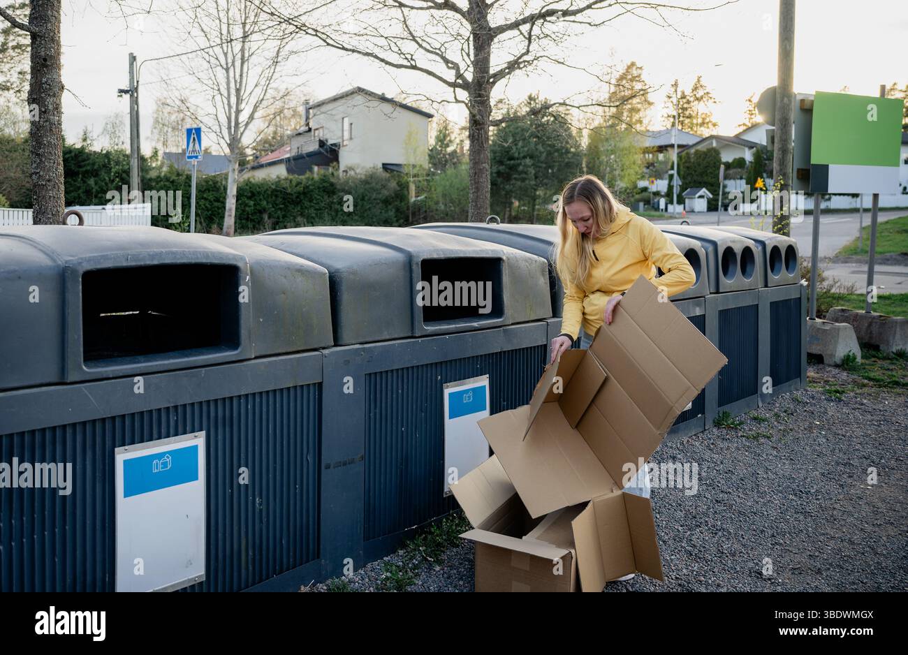 woman puts cardboard trash in outdoor recycling bins Stock Photo - Alamy