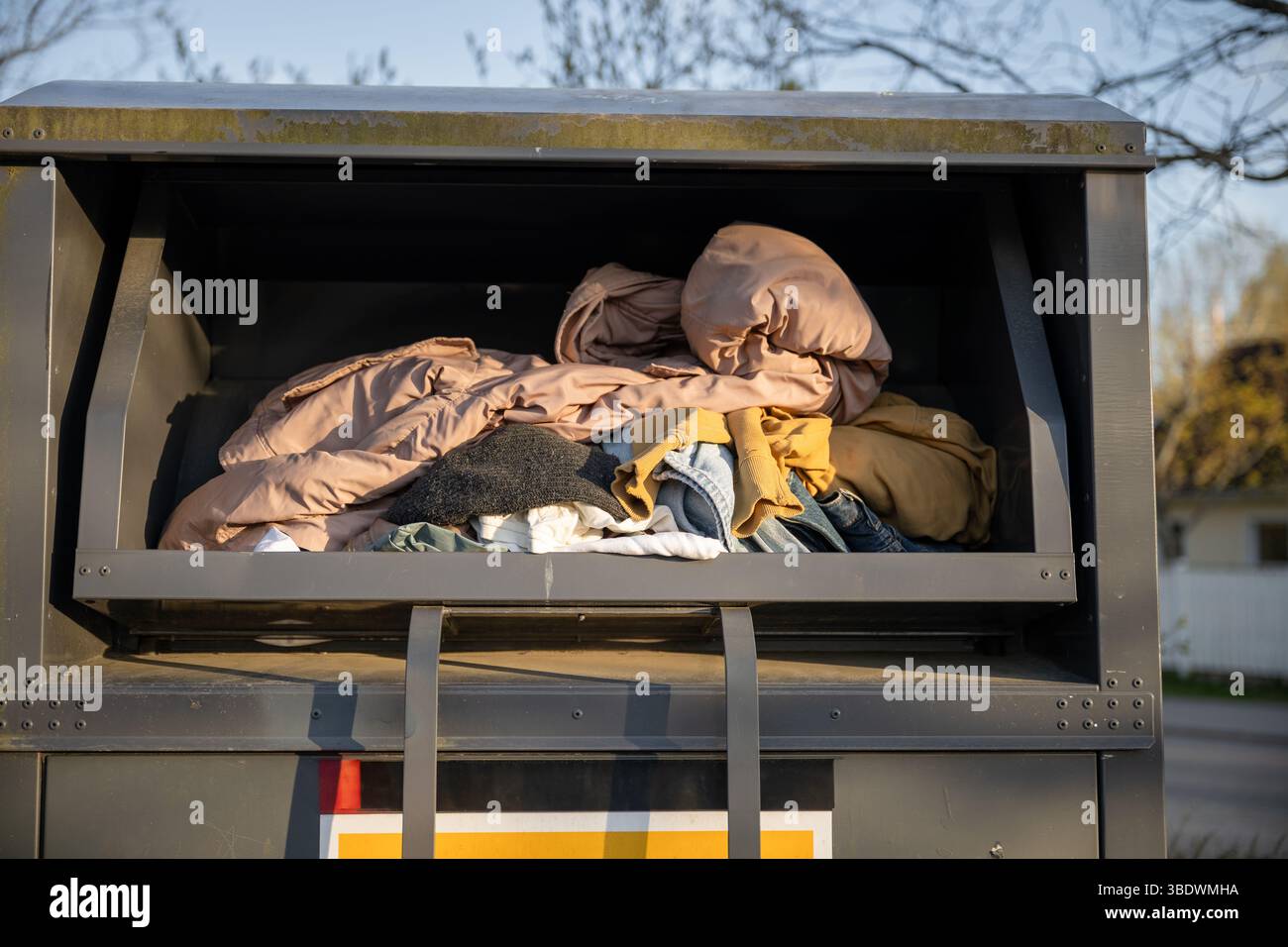 pile of mixed used clothes in an outdoor recycling container Stock ...