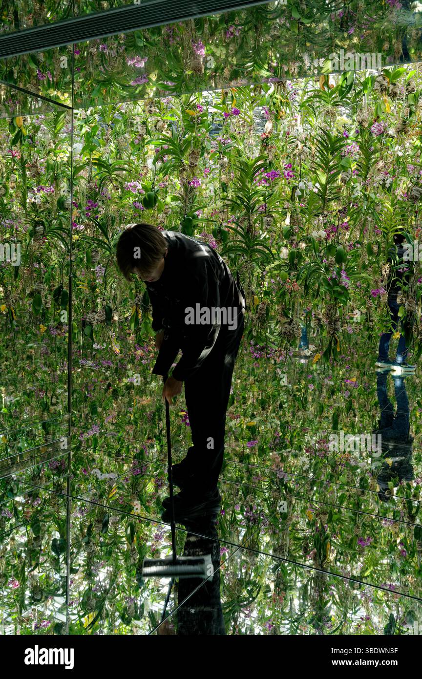 A staff member tends to the mirrored floor inside teamLab Planets ...