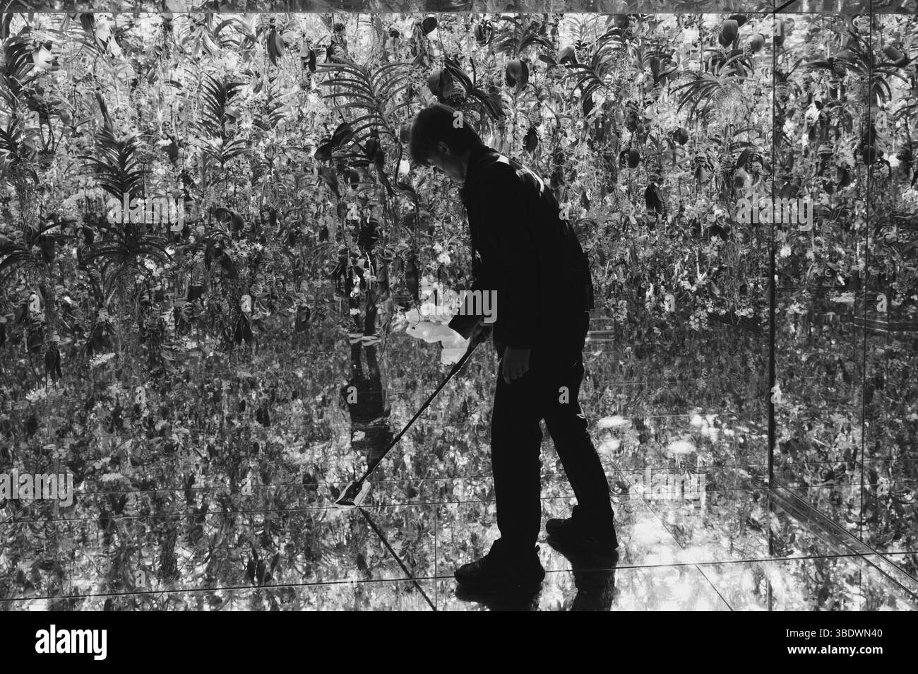 A staff member tends to the mirrored floor inside teamLab Planets ...