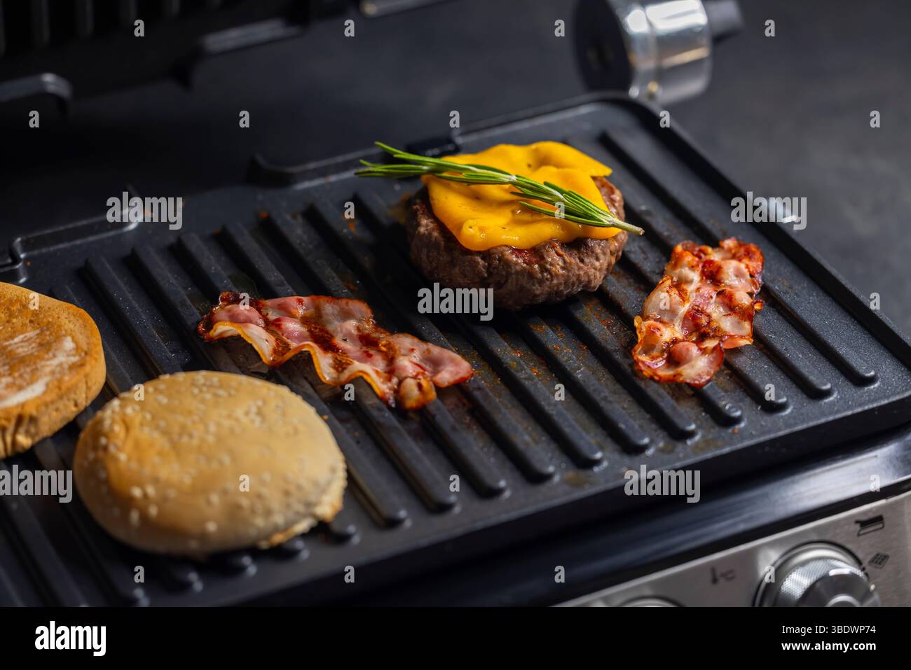 making cheeseburger on the electric grill Stock Photo - Alamy