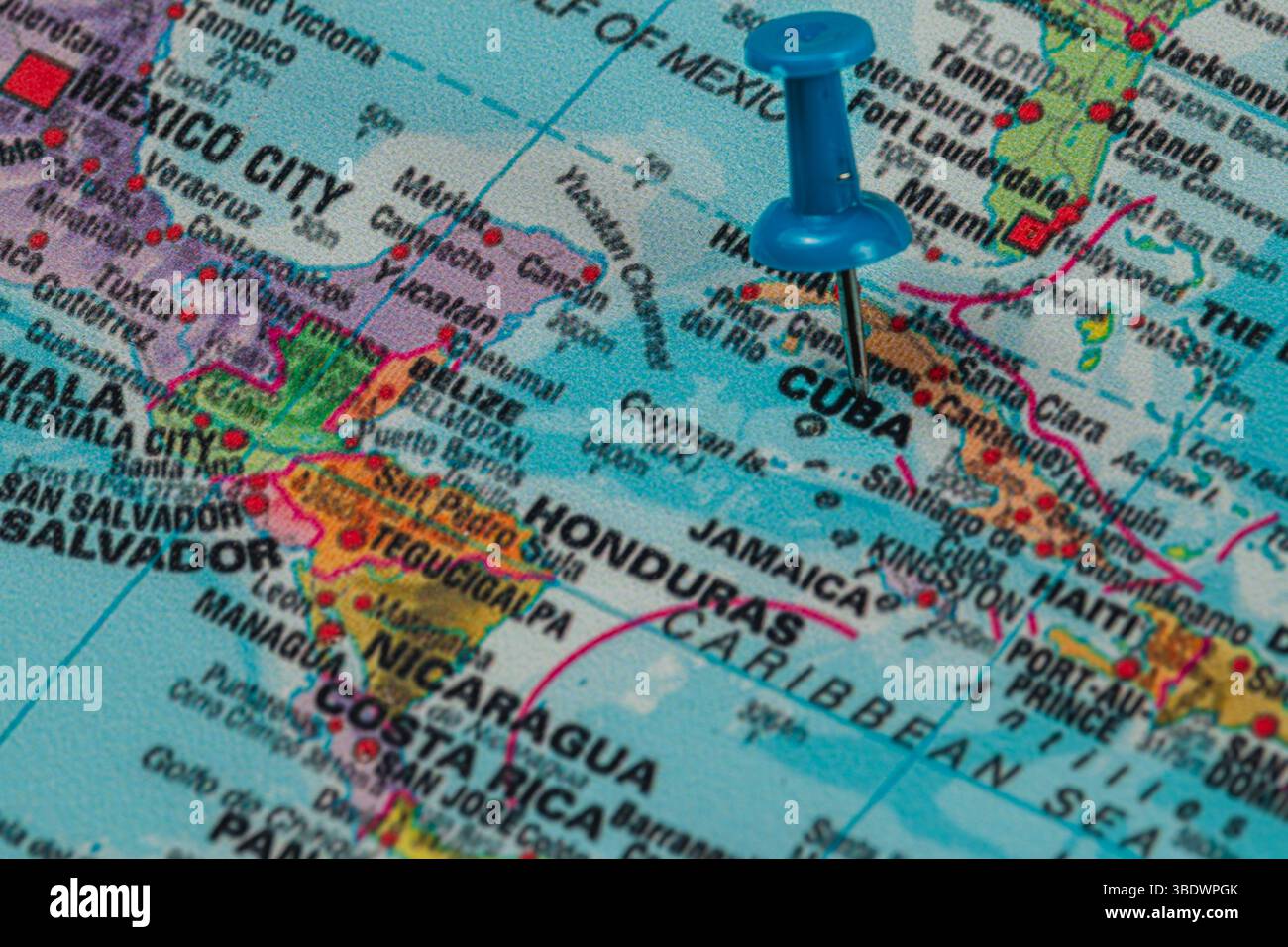 A blue pin is placed on Cuba on a vibrant world map, showcasing ...