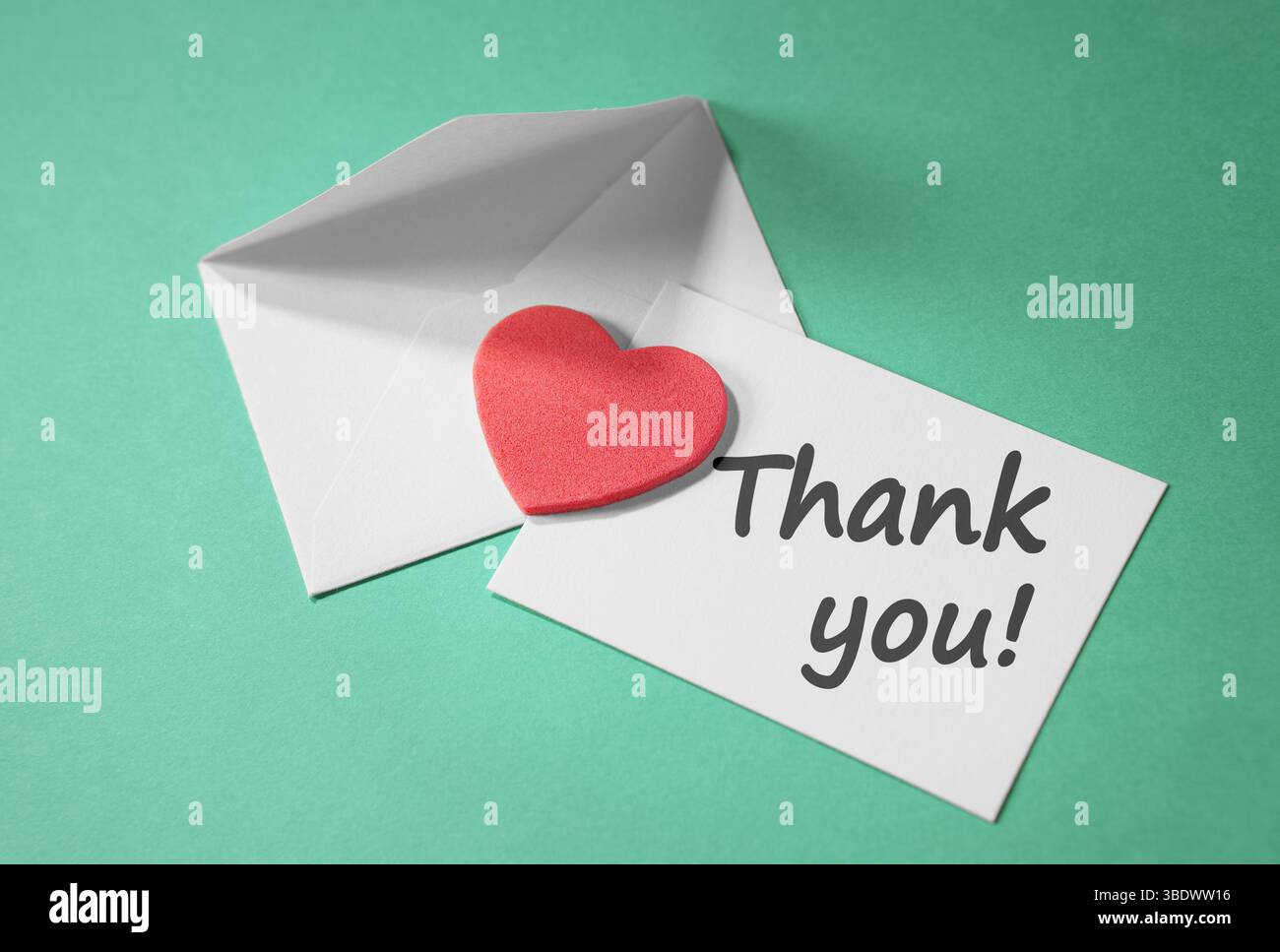 Thank you card concept with sign and a red heart shape on a paper mail ...