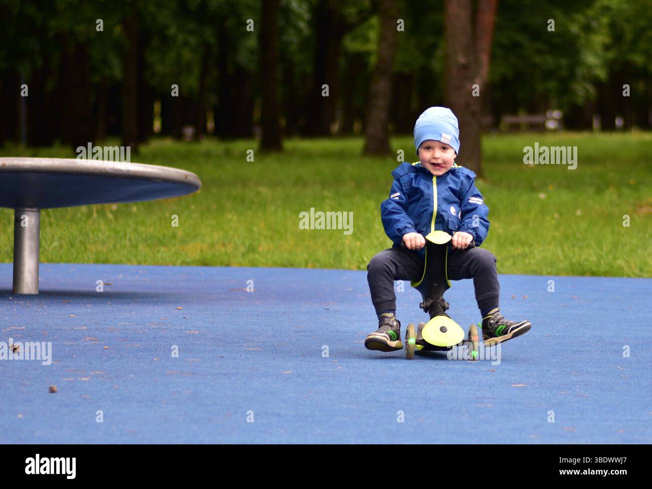 Happy toddler boy open mouth visible tongue sitting funny on green ...
