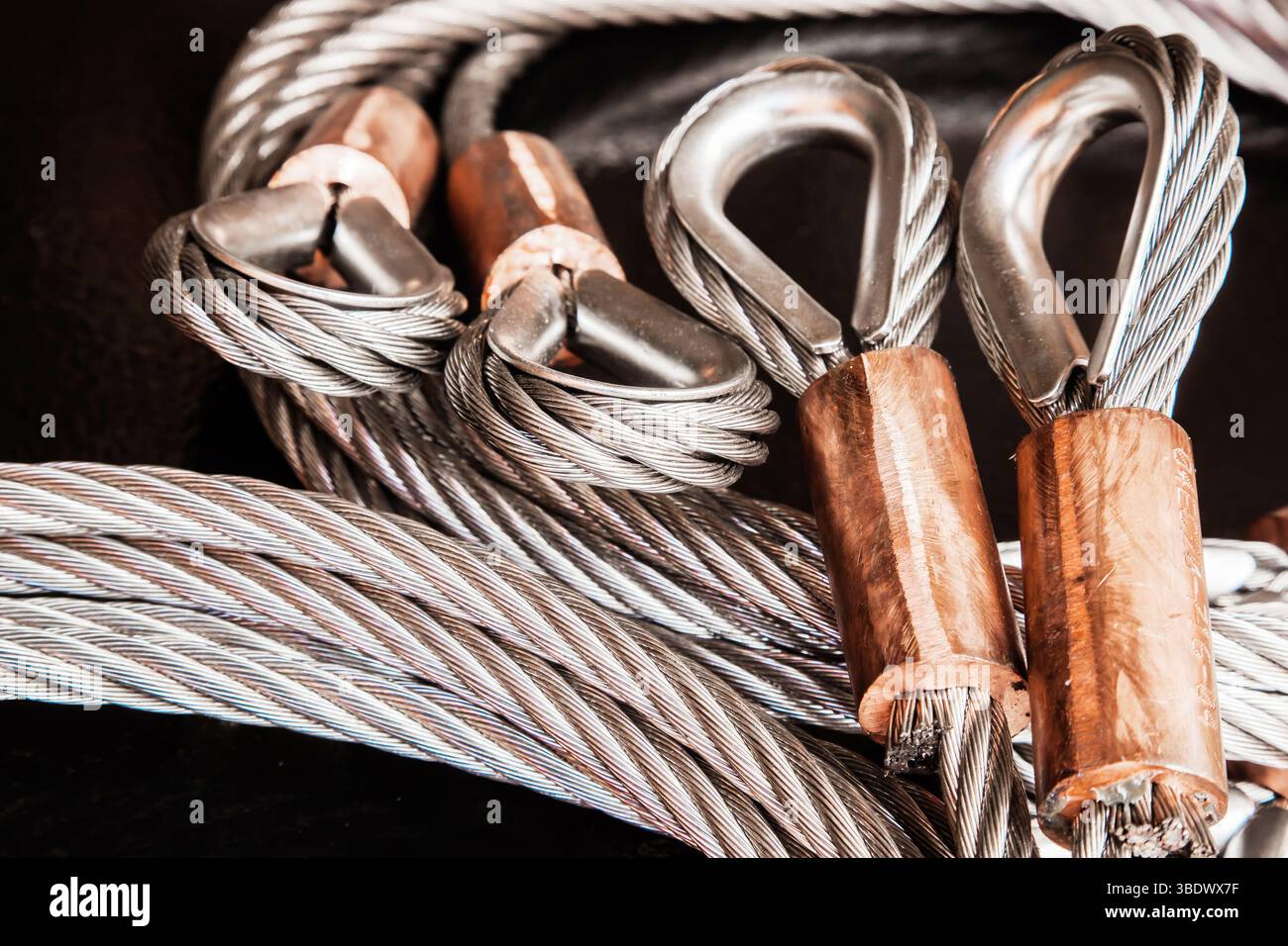 Stainless steel cable, with loops and copper clamps, and a black ...