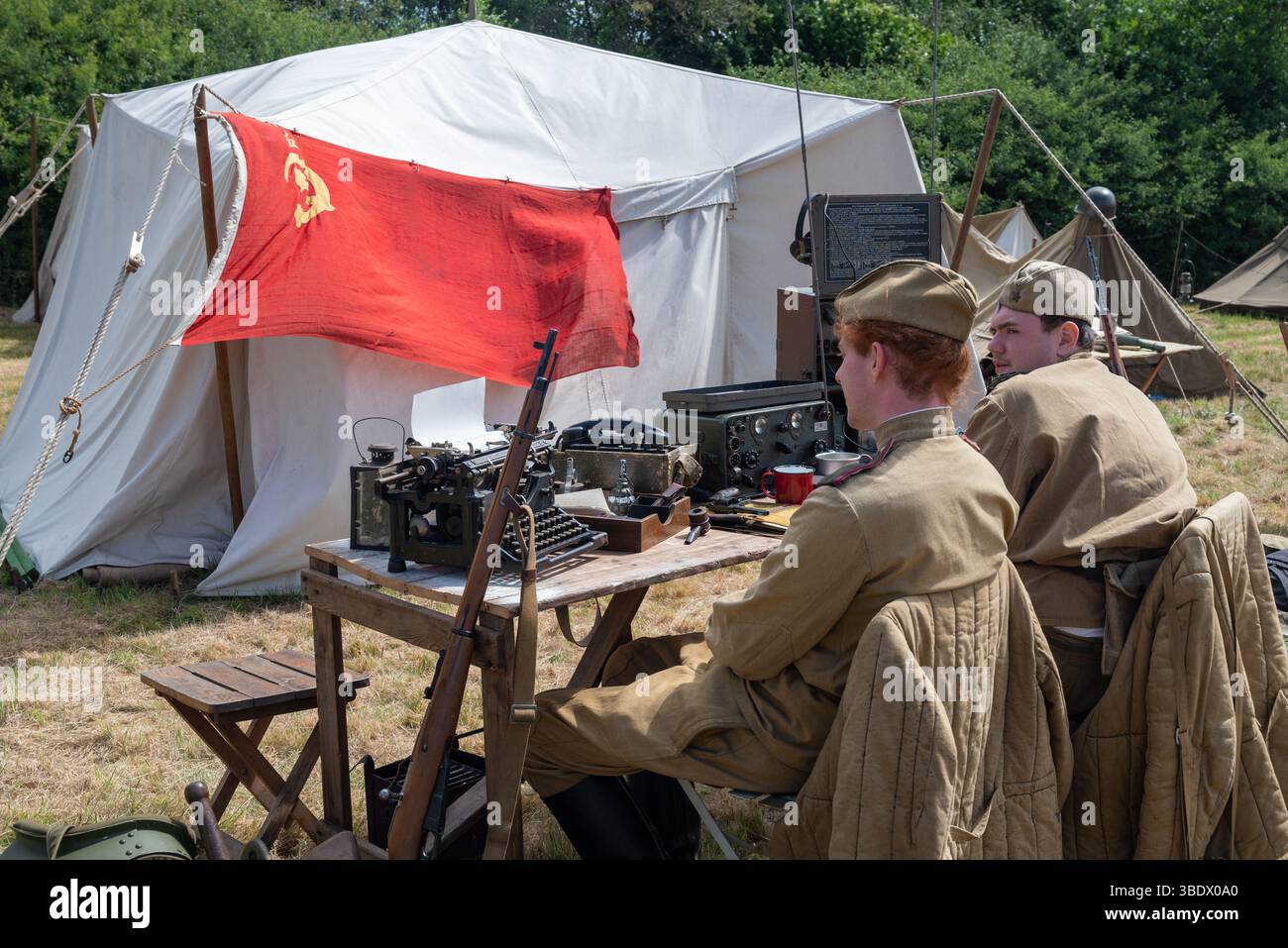 Reenactors dressed in WW2 Soviet military uniforms, sat at a desk with ...