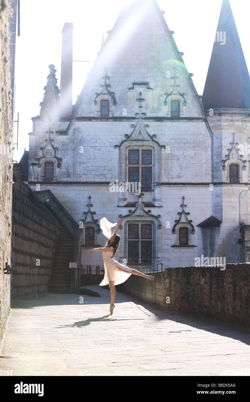 Ballet dancer leaping in sunlight by historic French castle Stock Photo ...