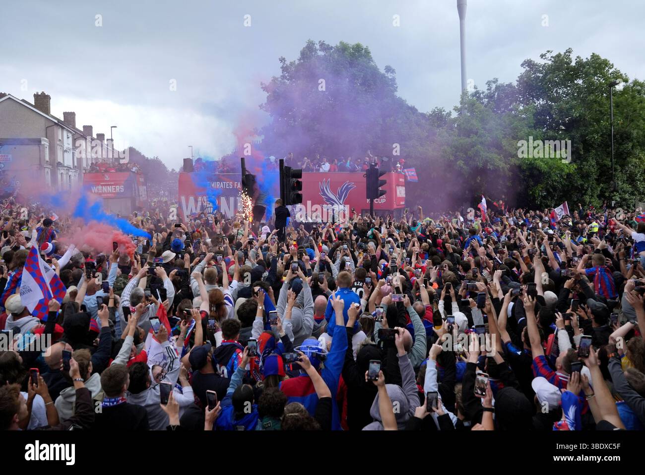 Crystal Palace fans watch as the team passes by on open-top buses ...