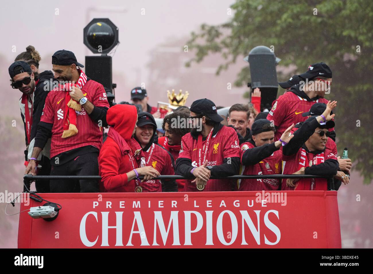 Liverpool players cheer on the top of a bus during the Liverpool FC ...