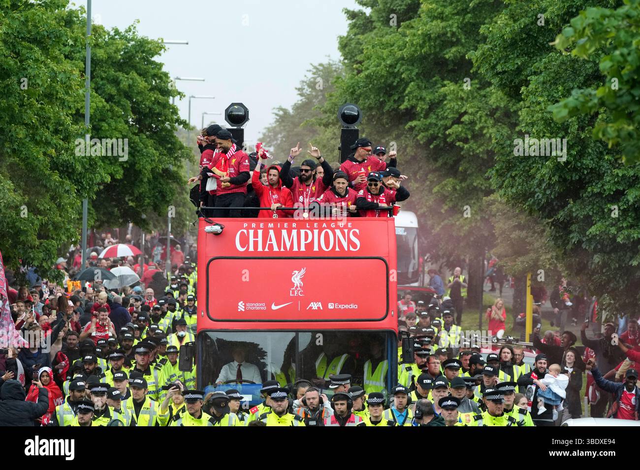 Liverpool players cheer on the top of a bus during the Liverpool FC ...