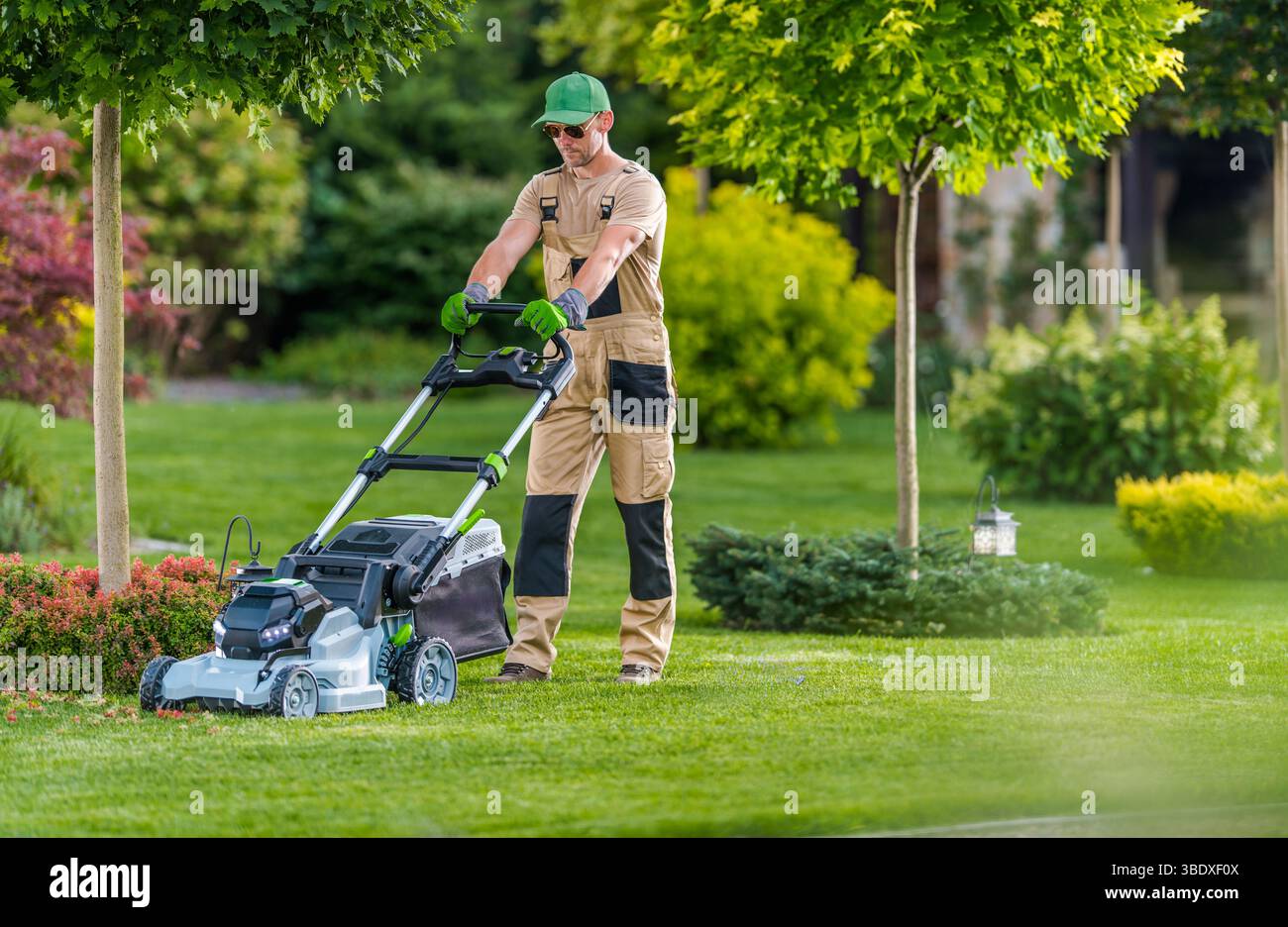 Worker operates mower in green hi-res stock photography and images - Alamy
