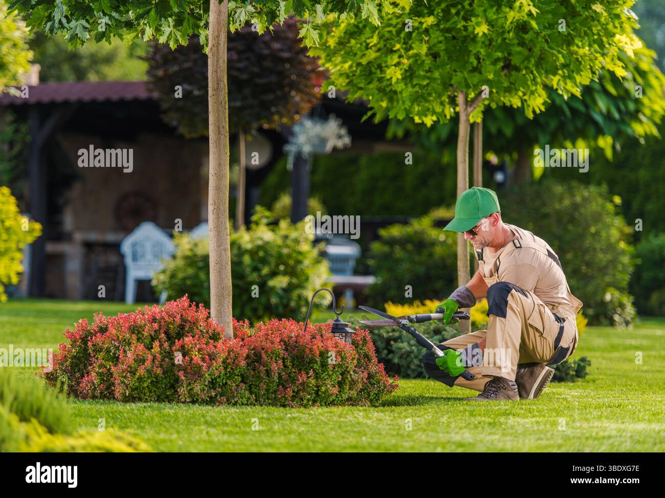 Gardener in hat trims flowers hi-res stock photography and images - Alamy