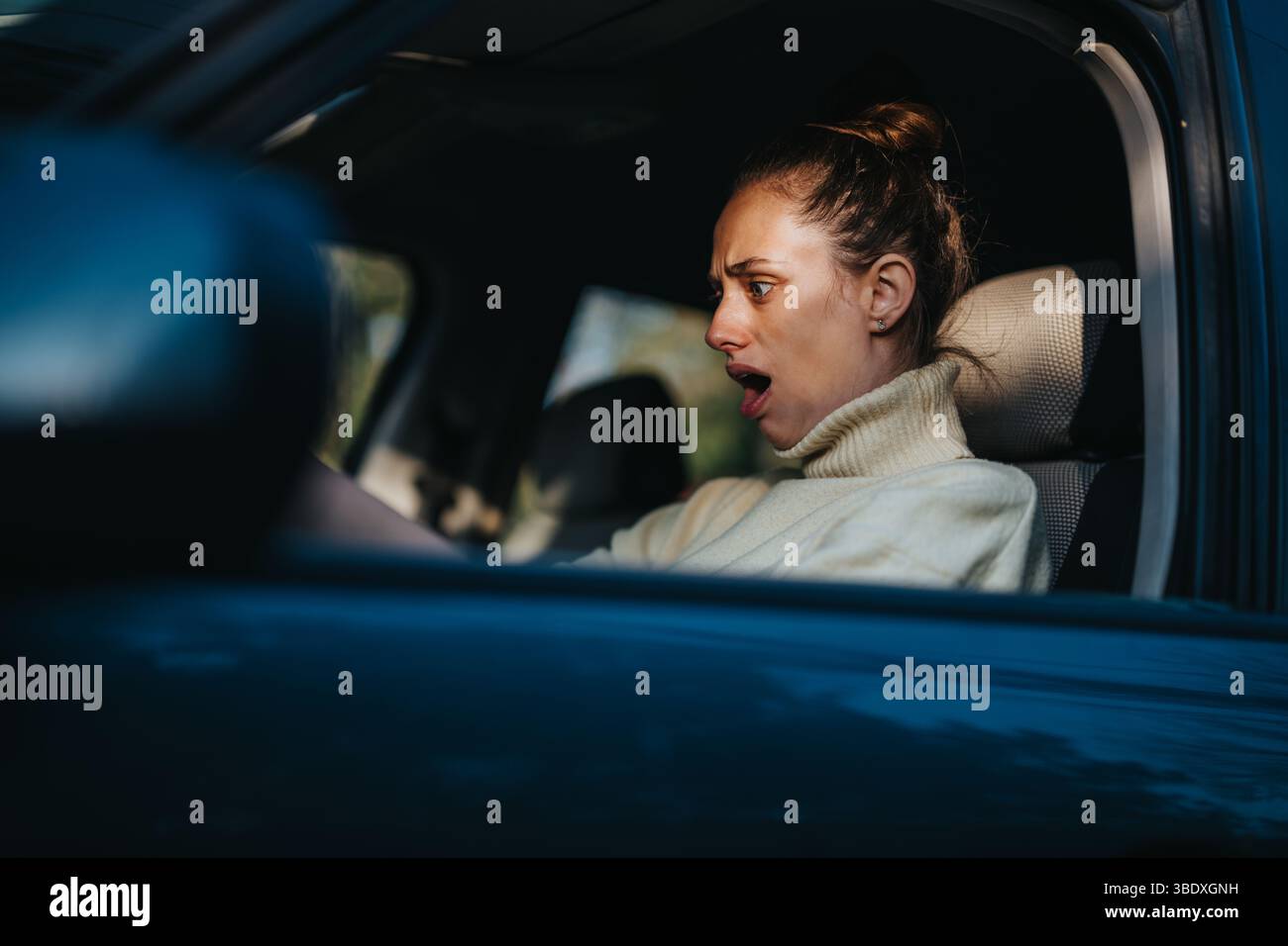 Shocked woman driving car with surprising expression on her face Stock ...