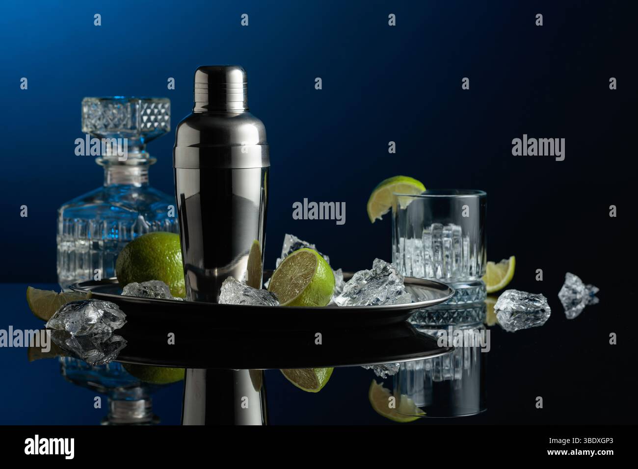 Shaker with ingredients for cocktail making. On a black reflective ...