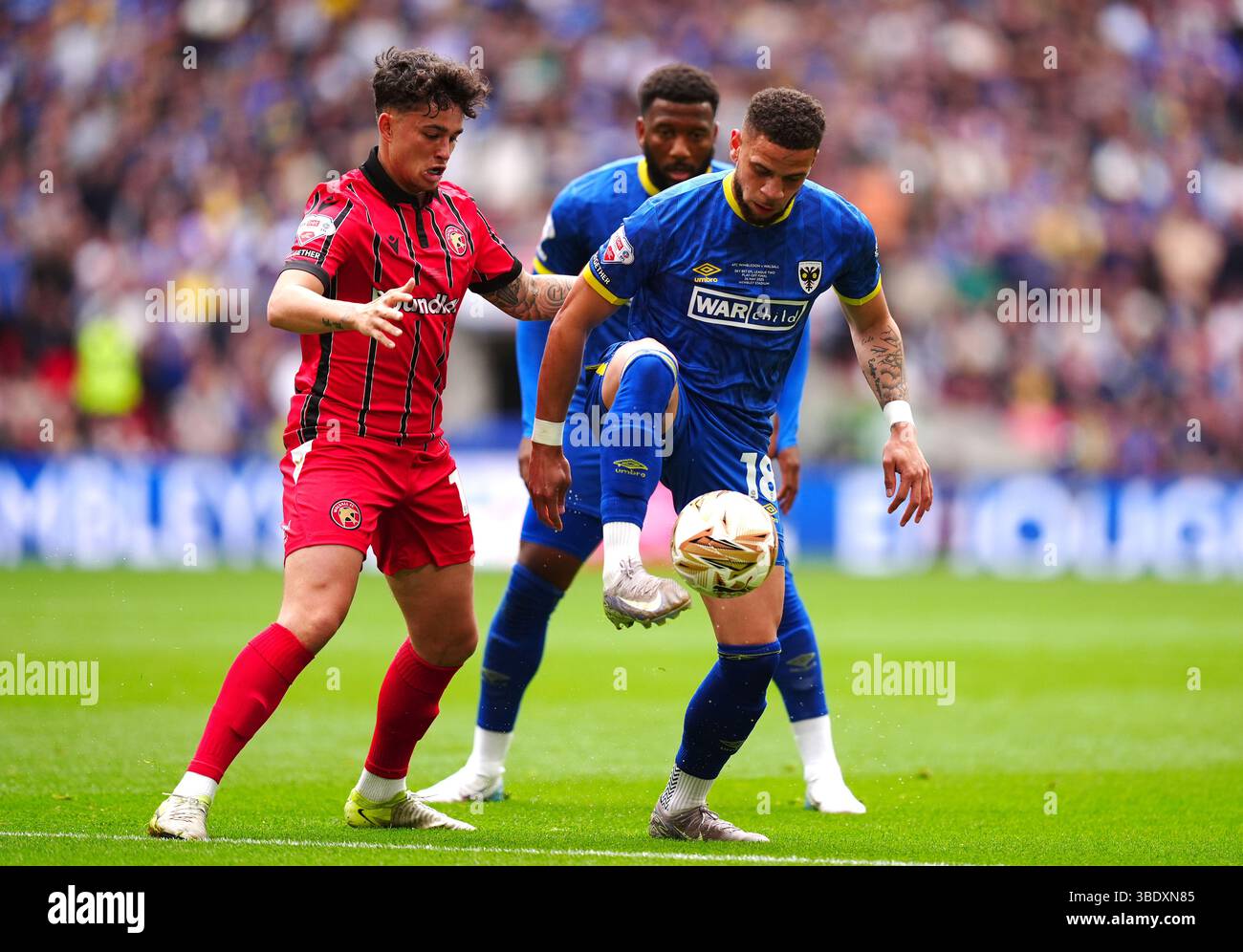 Walsall's Alfie Chang (left) and AFC Wimbledon's Marcus Browne battle for the ball during the ...