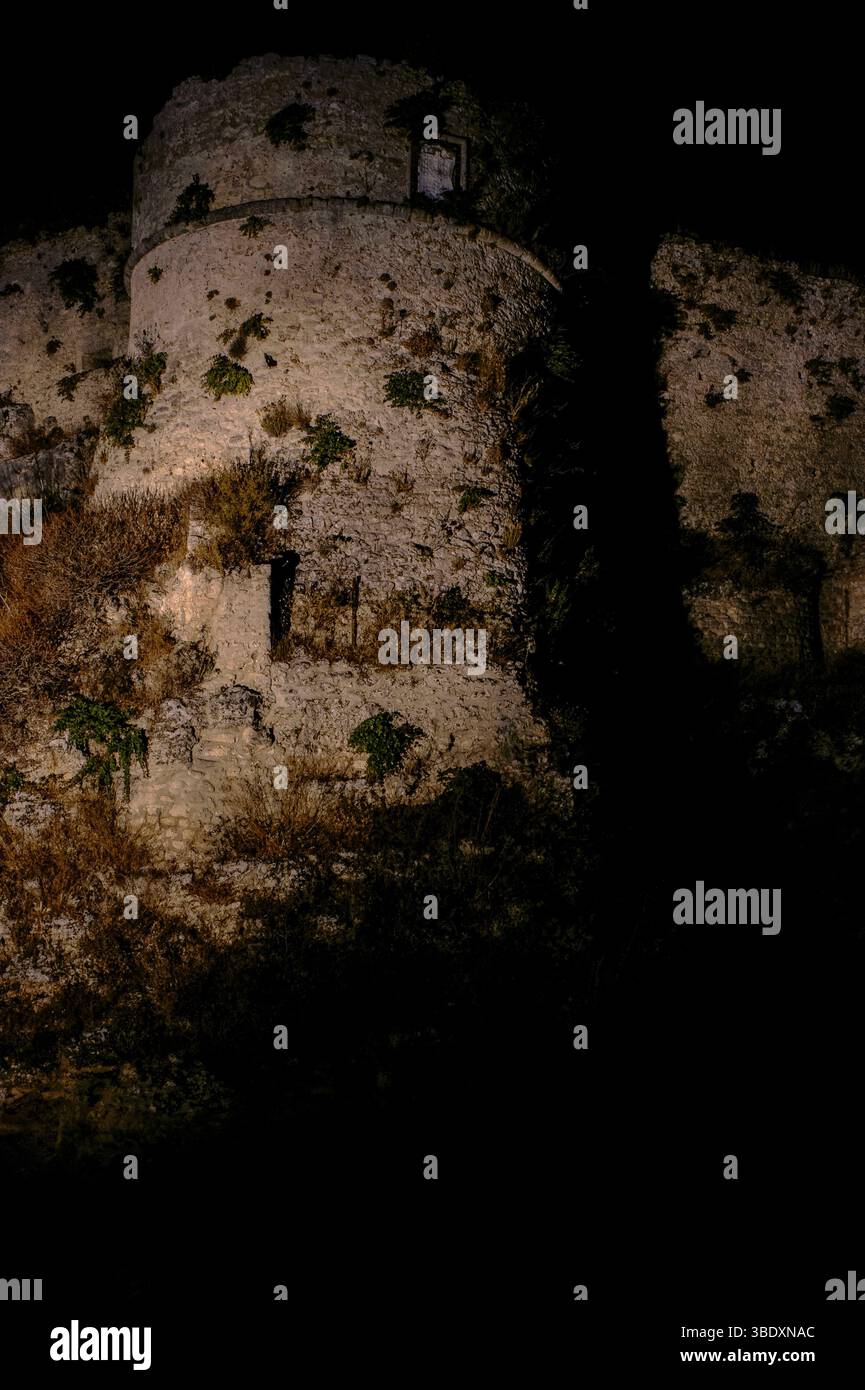 Night-time floodlighting reveals framed coat of arms on overgrown drum ...