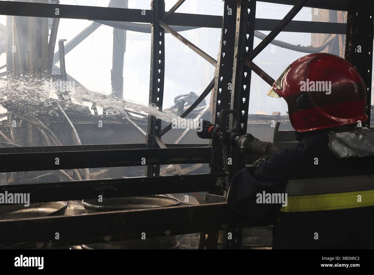 A firefighter of the State Emergency Service puts out a fire at a ...