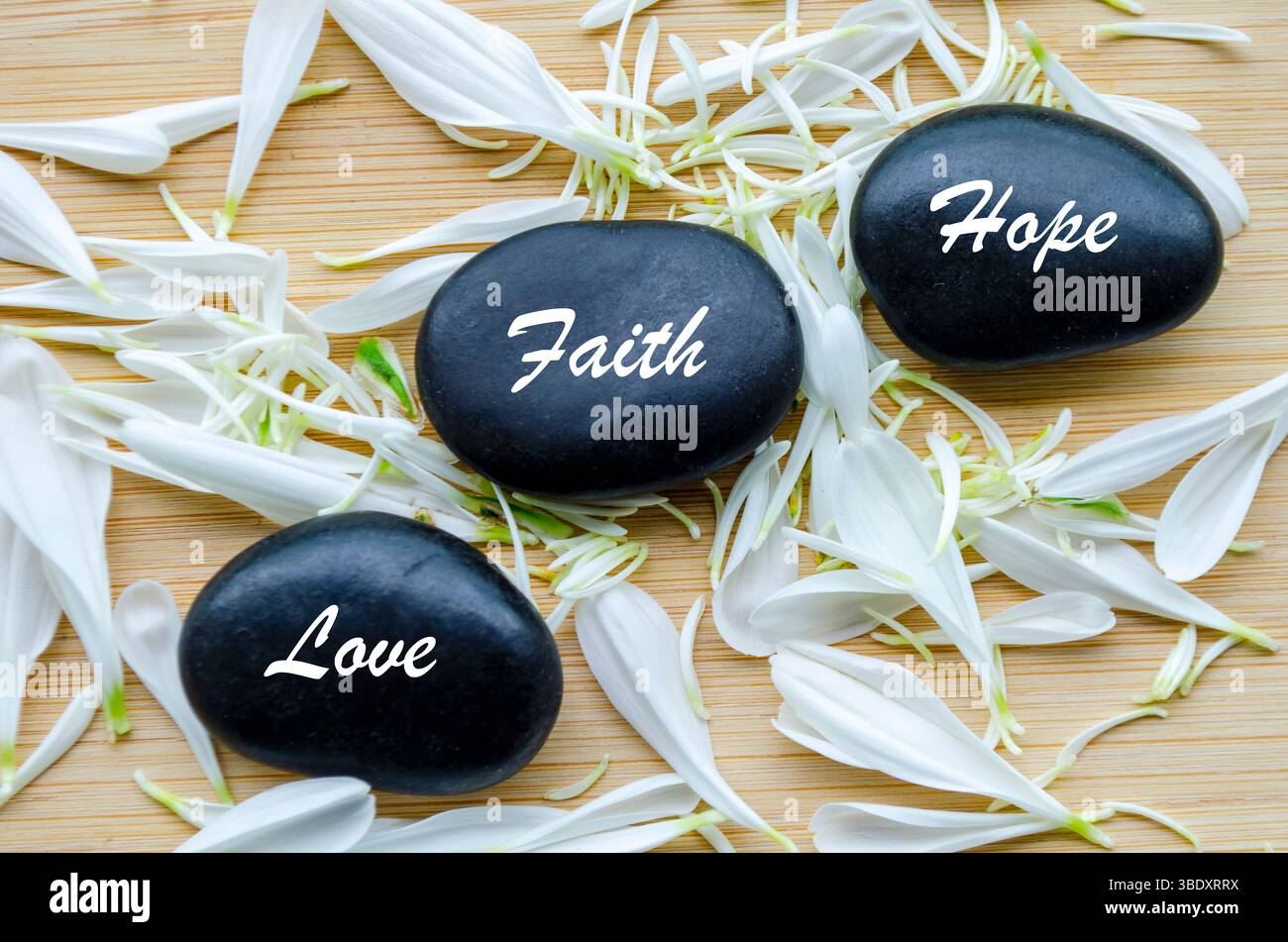 Top view of Hope, Faith and Love text on zen stones with white color ...