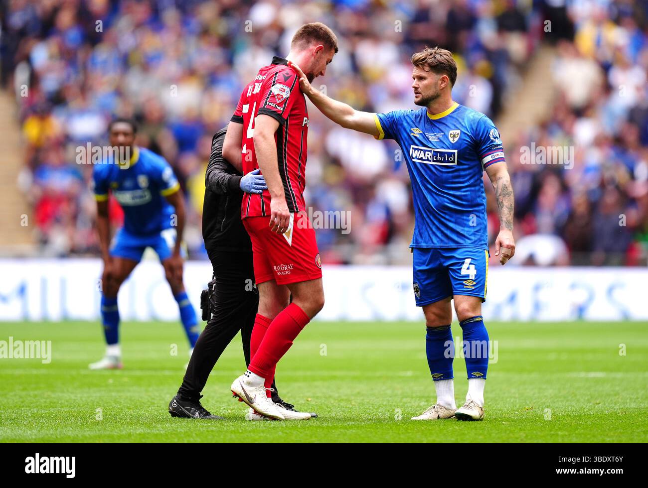 Walsall's Harry Williams is consoled by AFC Wimbledon's Jake Reeves ...