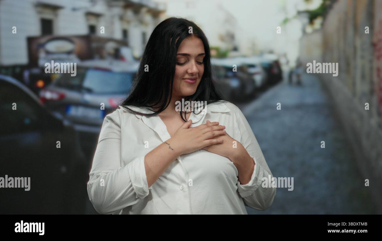 Woman with long black hair and plus size figure smiles while touching ...