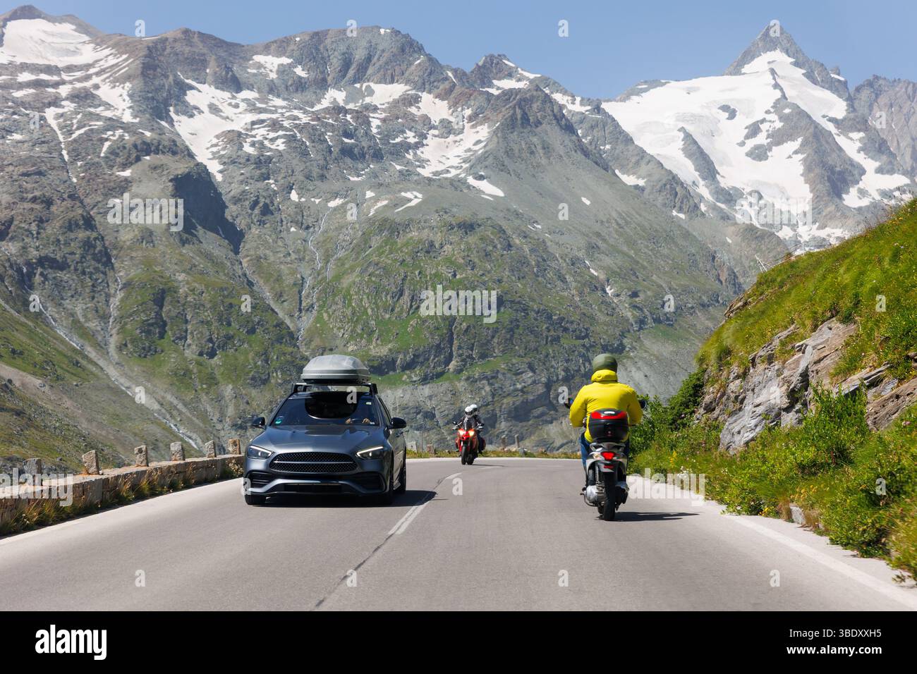 Cars and scooter drive Grossglockner High Alpine Road mountain green ...