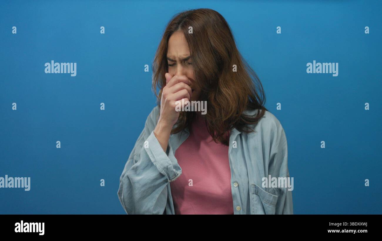 Young hispanic woman pinching nose hi-res stock photography and images ...
