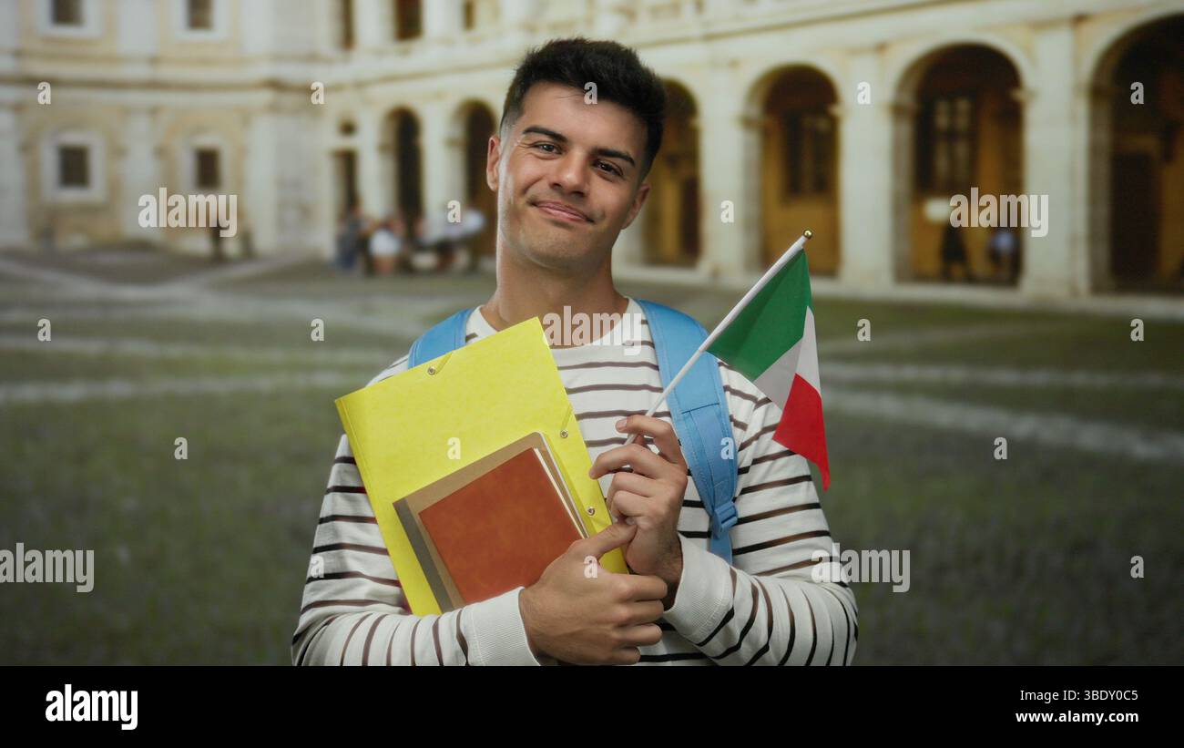 Italian student man smiles holding, books and italian flag in historic ...