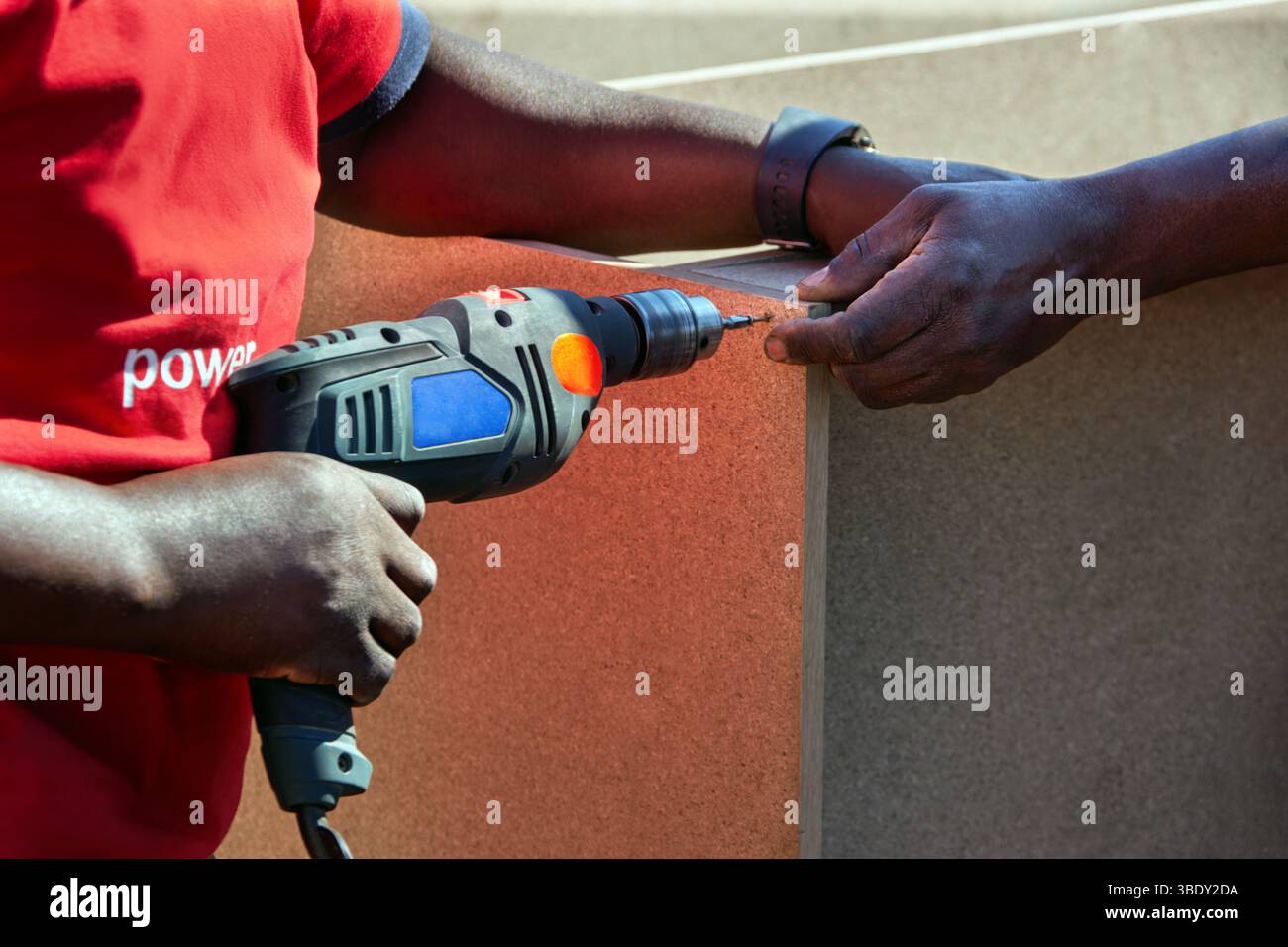 african american people using an electric drill driving screws into ...