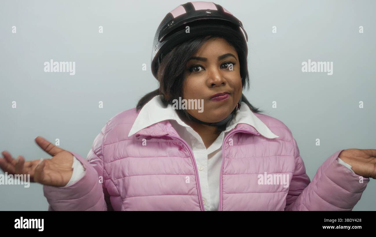 Woman gesturing in frustration wearing a pink jacket and helmet against ...