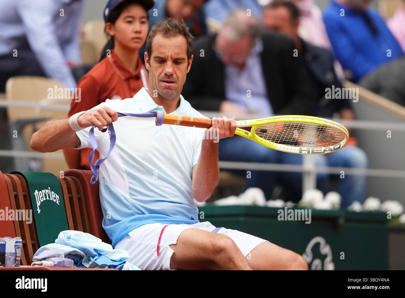 France's Richard Gasquet changes the overgrip of his racket as he plays ...