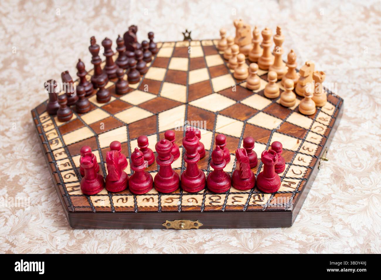 Three player chess board with black, white and red color pieces, on ...