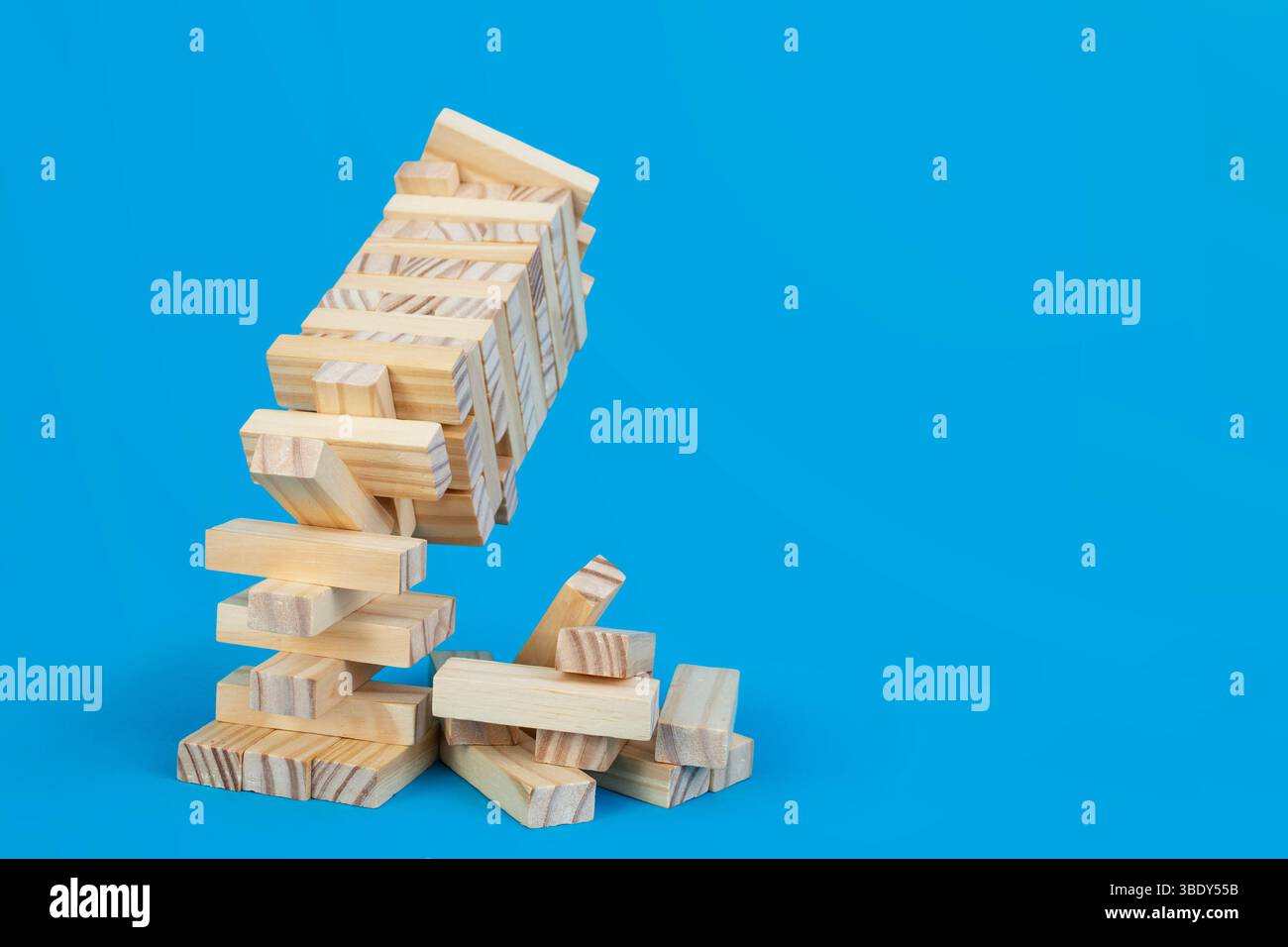Collapsing wooden blocks tower on blue background, close up Stock Photo ...