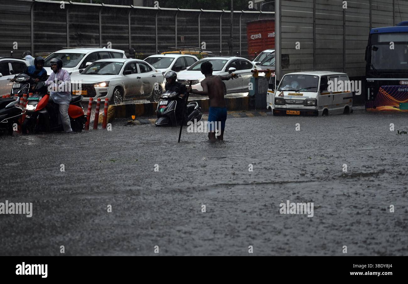 MUMBAI, INDIA - MAY 26: Vehicles wade through waterlogged road at Gandhi Market in the Sion area ...
