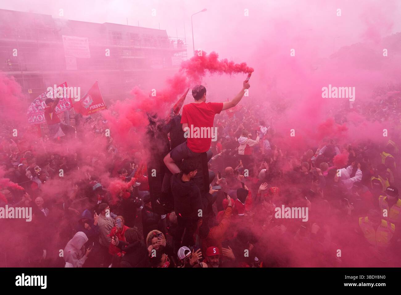 Liverpool fans celebrate with red flares as football players tour the ...