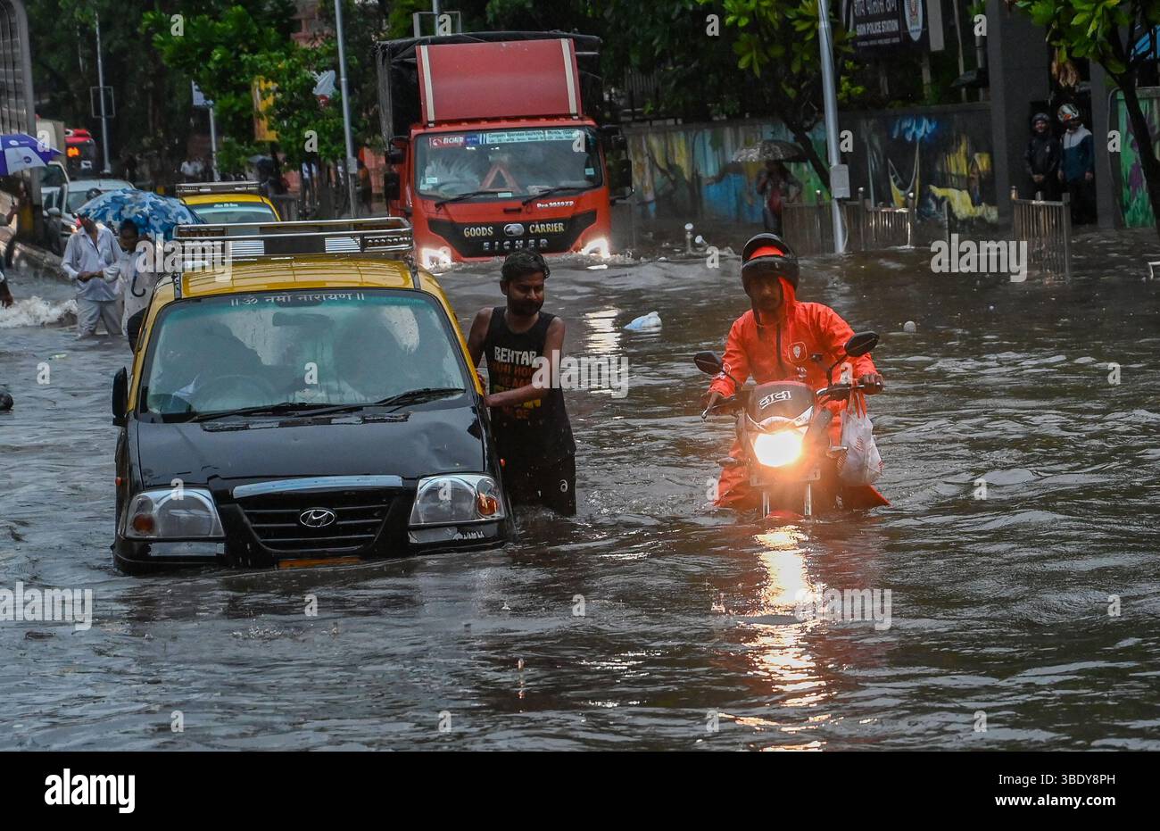 MUMBAI, INDIA - MAY 26: Vehicles wade through waterlogged road at Gandhi Market in the Sion area ...