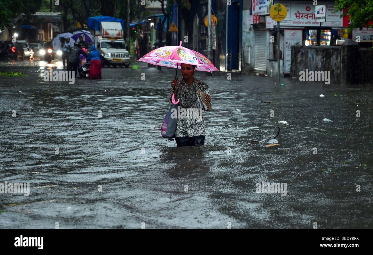 MUMBAI, INDIA - MAY 26: People wade through waterlogged road at Gandhi Market in the Sion area ...