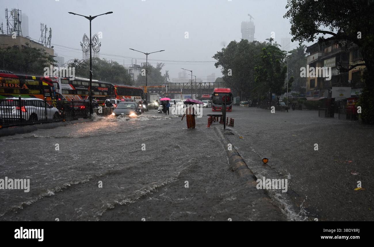 MUMBAI, INDIA - MAY 26: People wade through waterlogged road at Gandhi Market in the Sion area ...