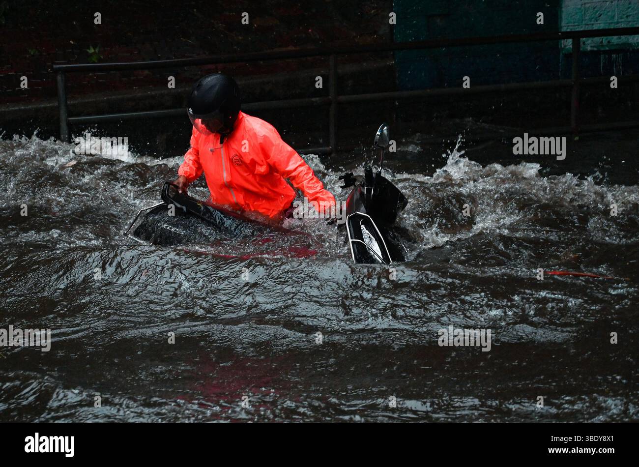 MUMBAI, INDIA - MAY 26: A biker stuck in a waterlogged road at Gandhi Market in the Sion area ...