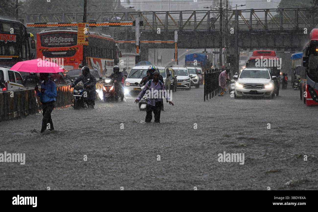 MUMBAI, INDIA - MAY 26: People wade through waterlogged road at Gandhi Market in the Sion area ...