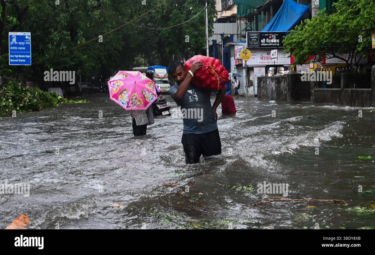 MUMBAI, INDIA - MAY 26: People wade through waterlogged road at India Nagar in the Sion area ...