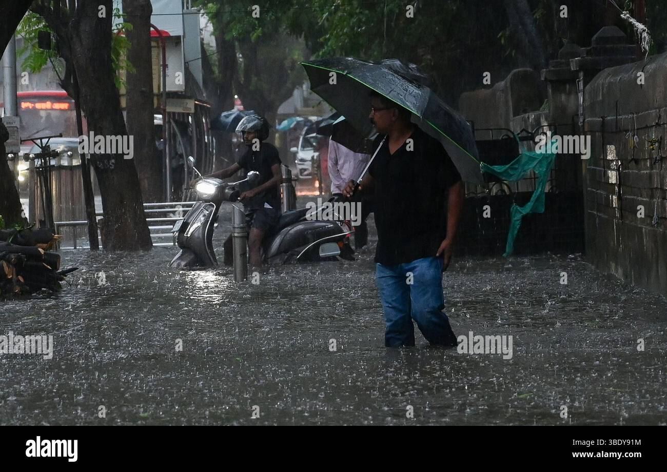 MUMBAI, INDIA - MAY 26: People wade through waterlogged road at Gandhi Market in the Sion area ...